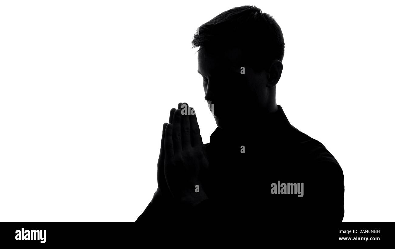 Young man shadow praying, asking forgiveness, religious ritual ...