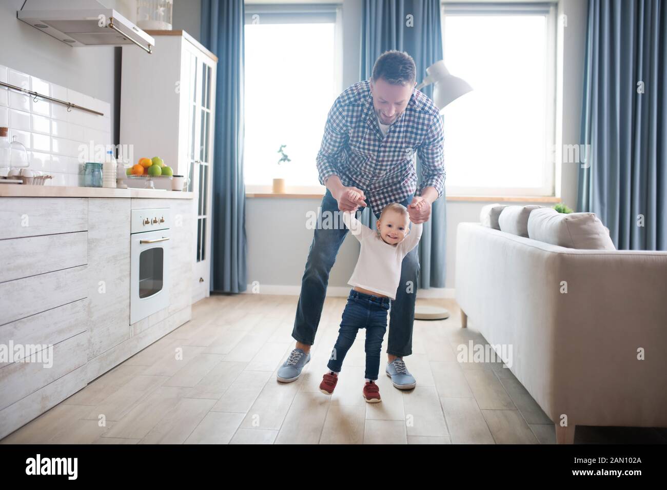 Small cute baby girl making her first steps with dads help Stock Photo ...