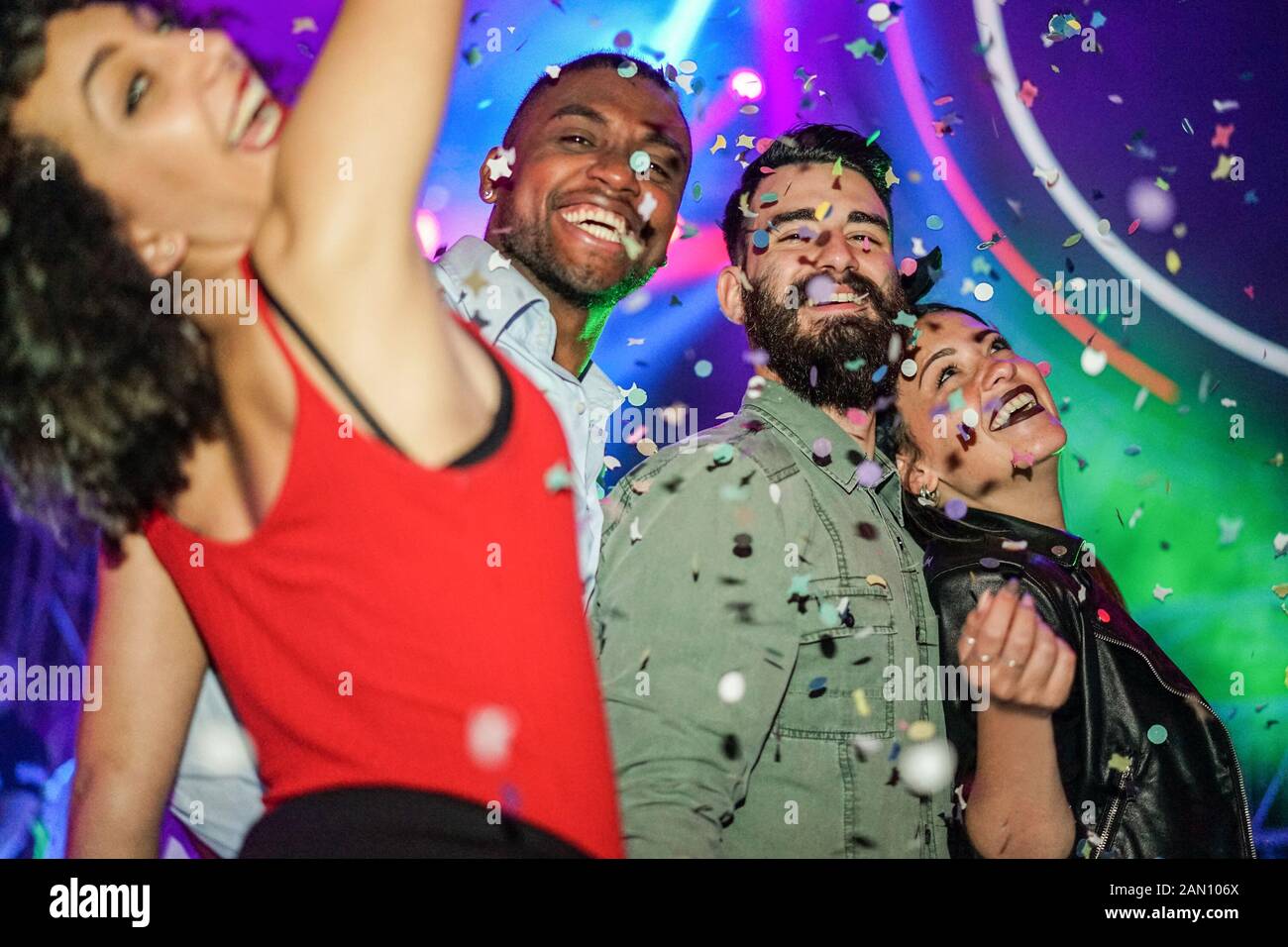 Happy friends having fun in night club dance floor with canon ball ...