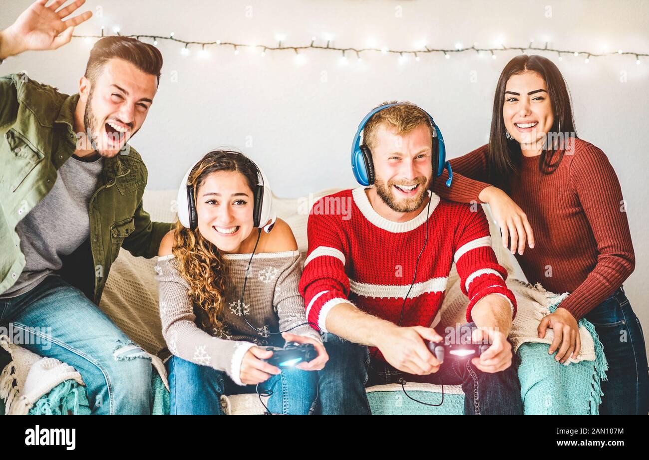 Group of millennials friends playing video games - Young people having ...