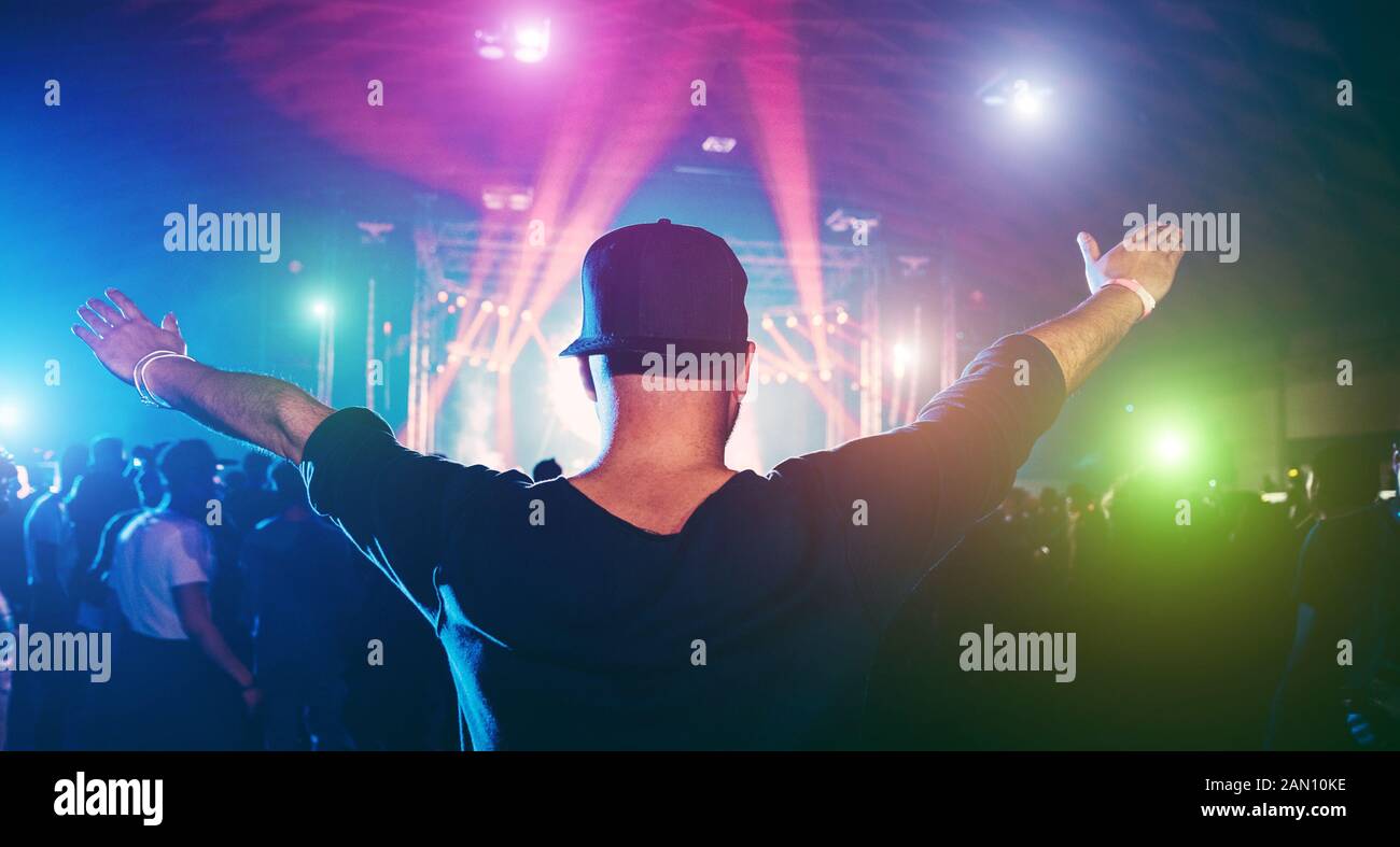 Young man dancing in night club festival event party with laser lights ...