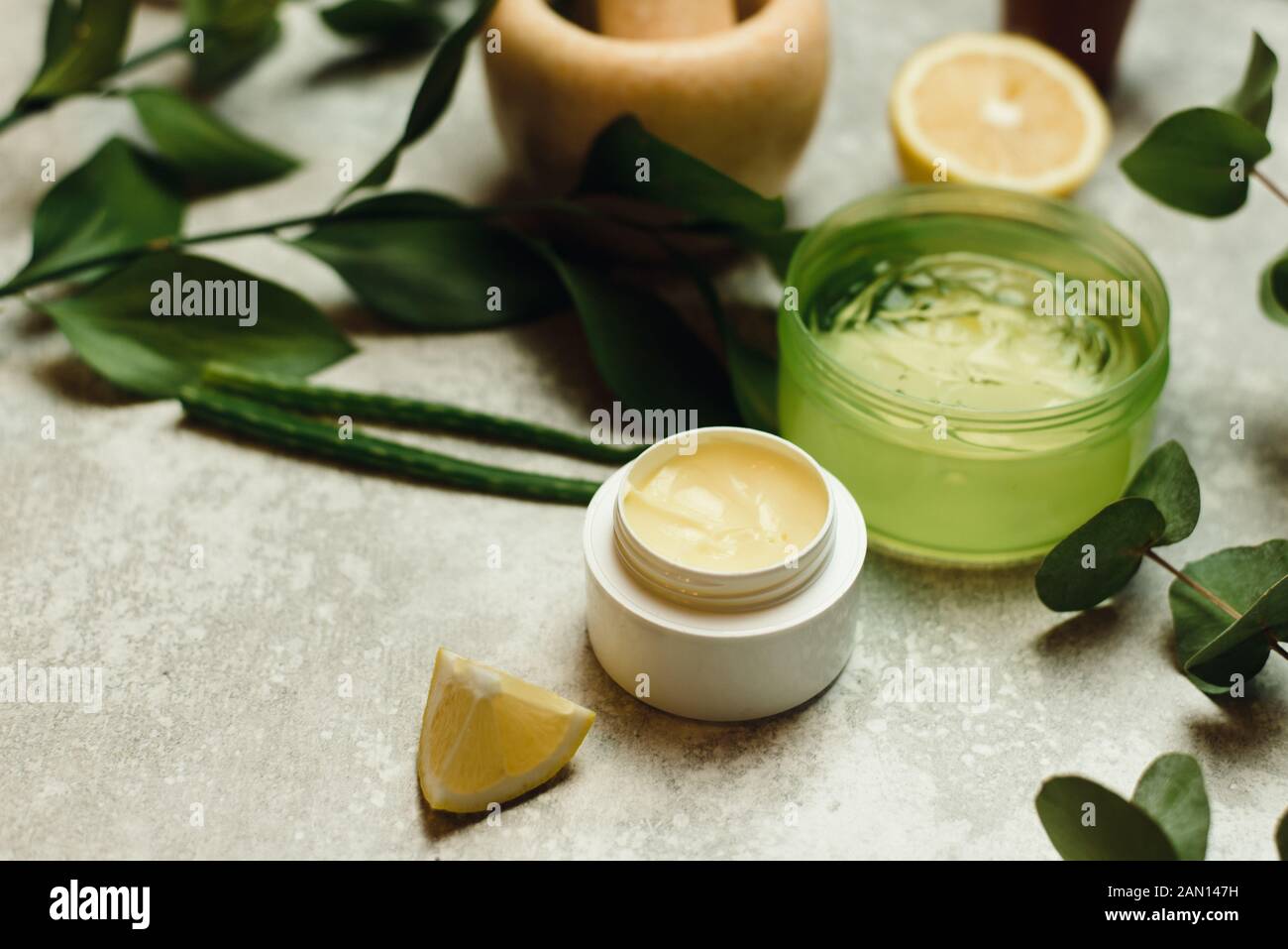 Yellow natural moisturizer in a white jar on a gray background. Cream ...