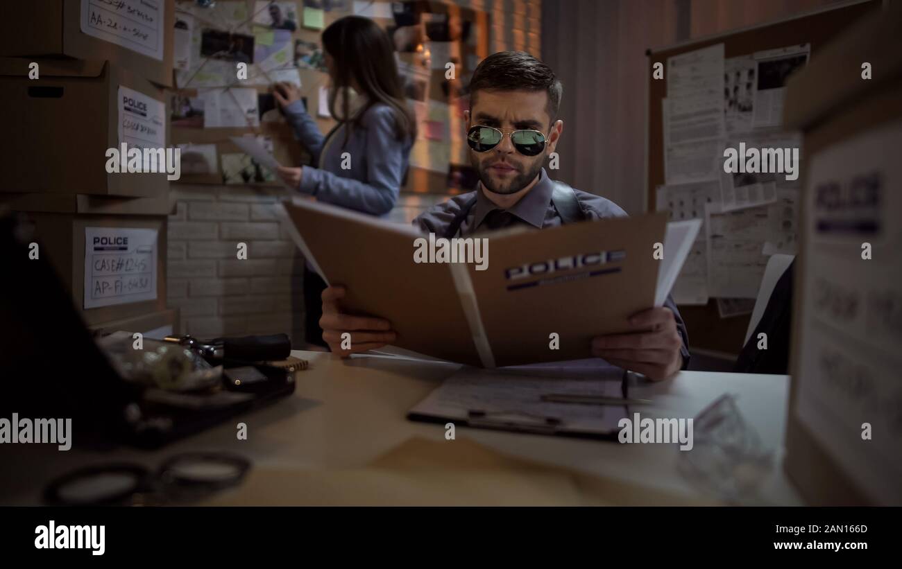 Cop analyzing witness statement files, paper working, preparing ...