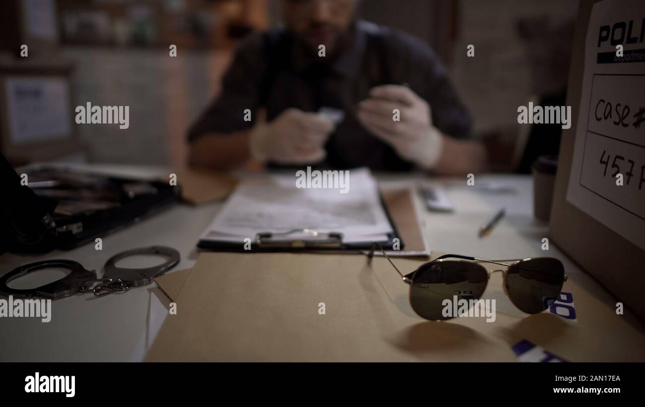 Policeman table, criminalist working, investigating murder, laboratory ...