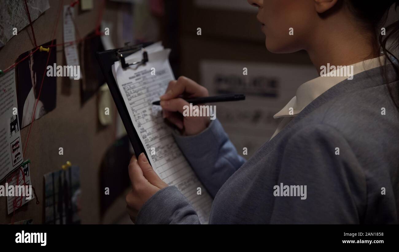Criminal investigator drawing up record, writing down case details ...