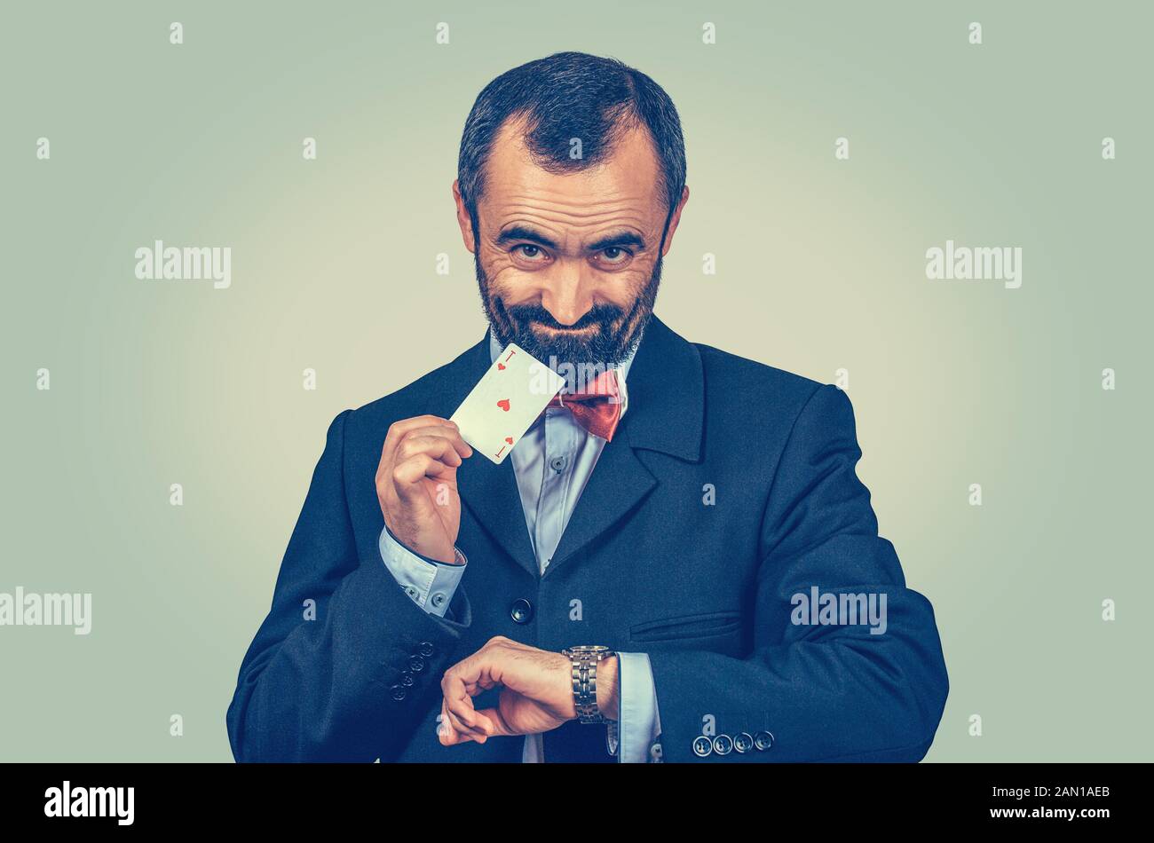 Bearded businessman showing ace card and watch, looking sly to you ...