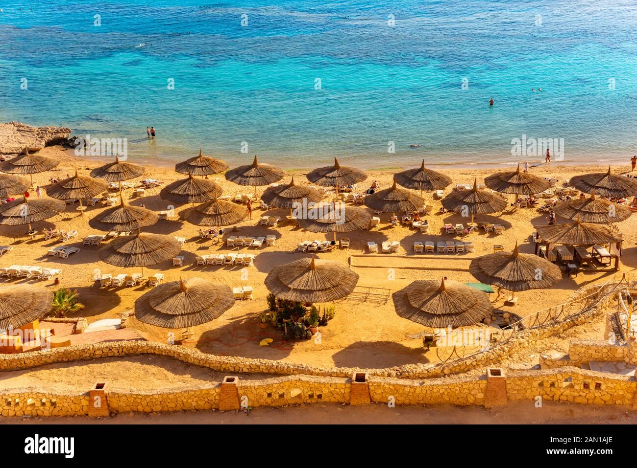 Red sea beach from aerial top view. Tourists relaxing under umbrellas ...