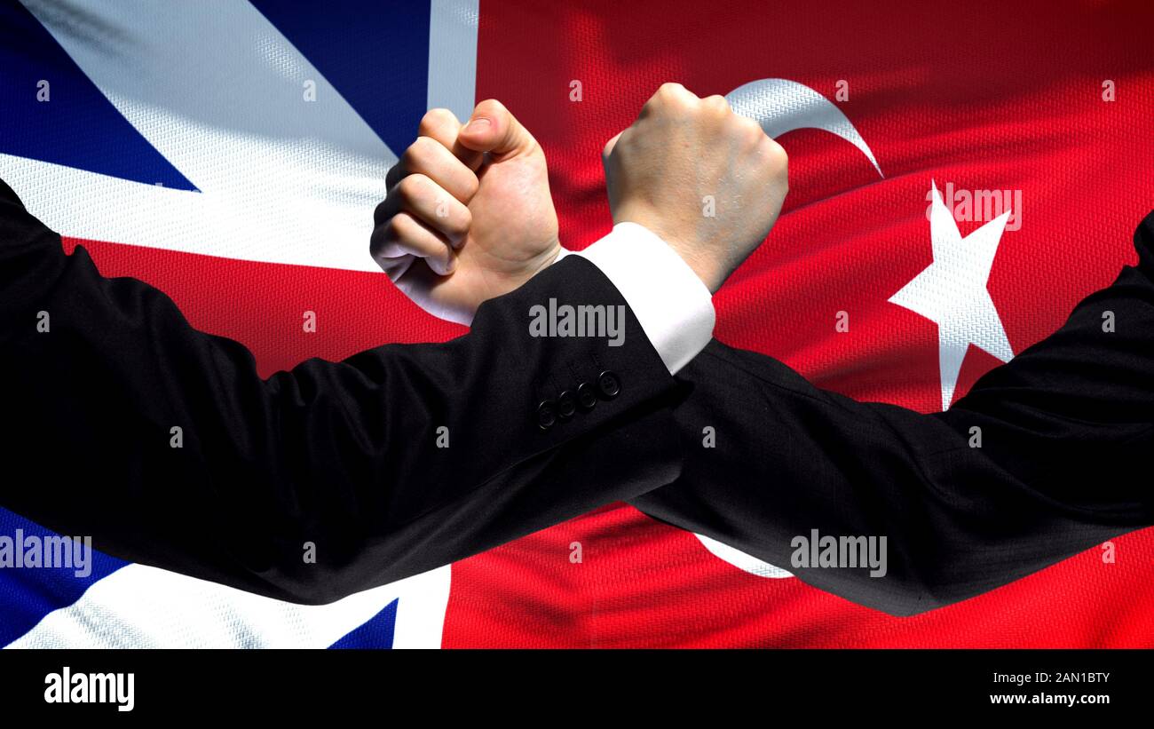 Great Britain vs Turkey confrontation, fists on flag background ...