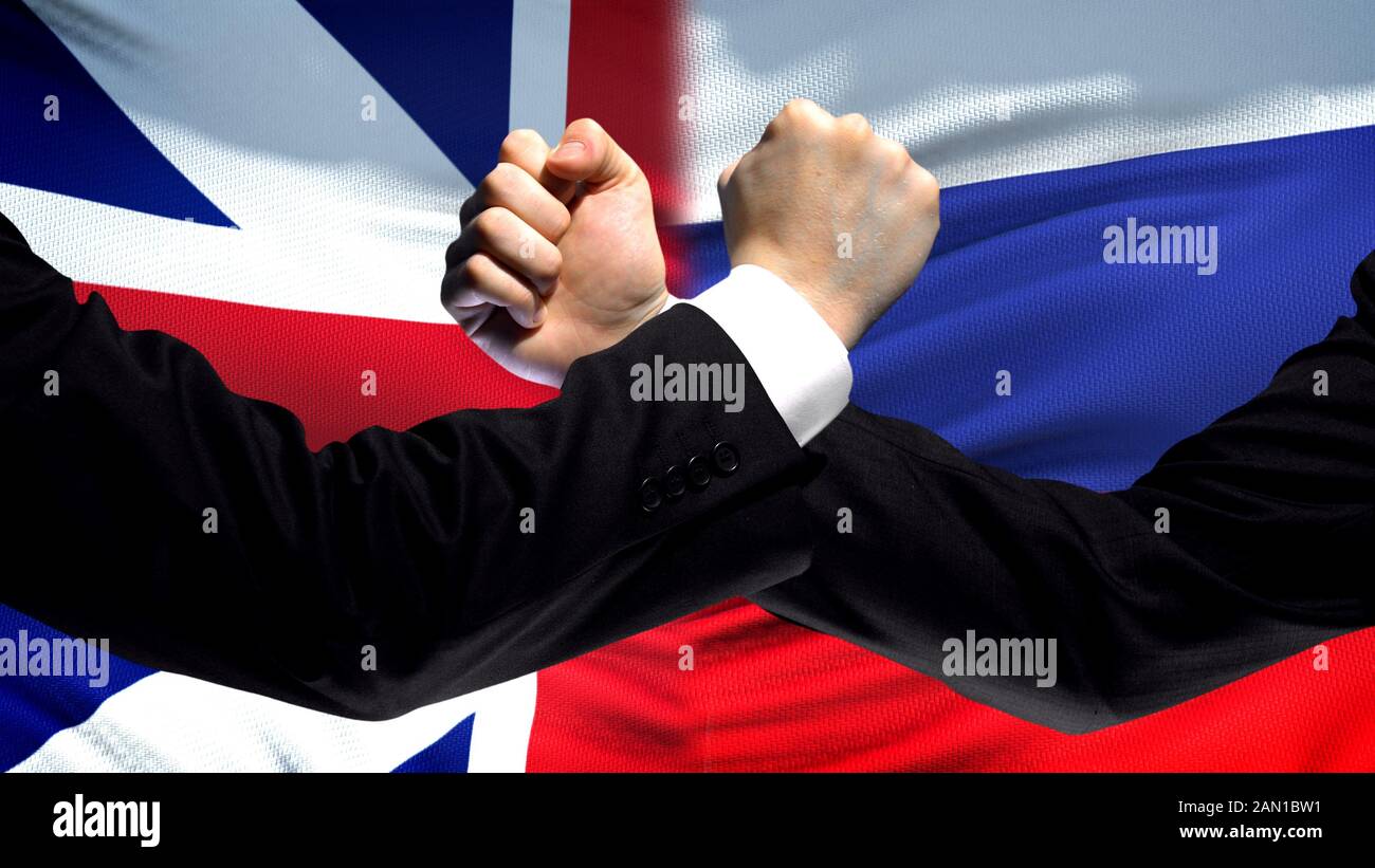 Great Britain vs Russia confrontation, fists on flag background ...