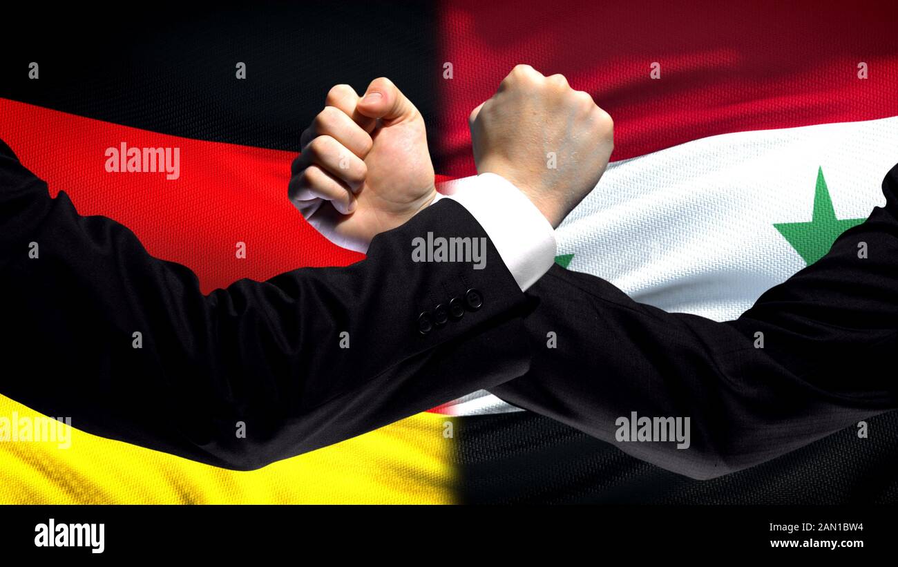 Germany vs Syria confrontation, countries disagreement, fists on flag ...