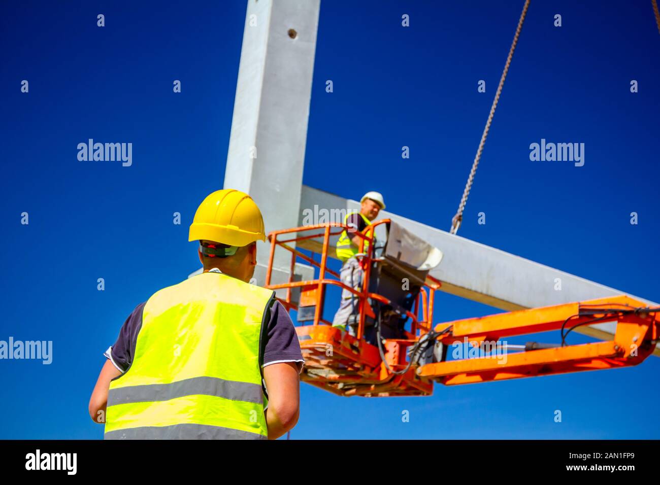 View from behind on construction worker with safety vest and yellow ...