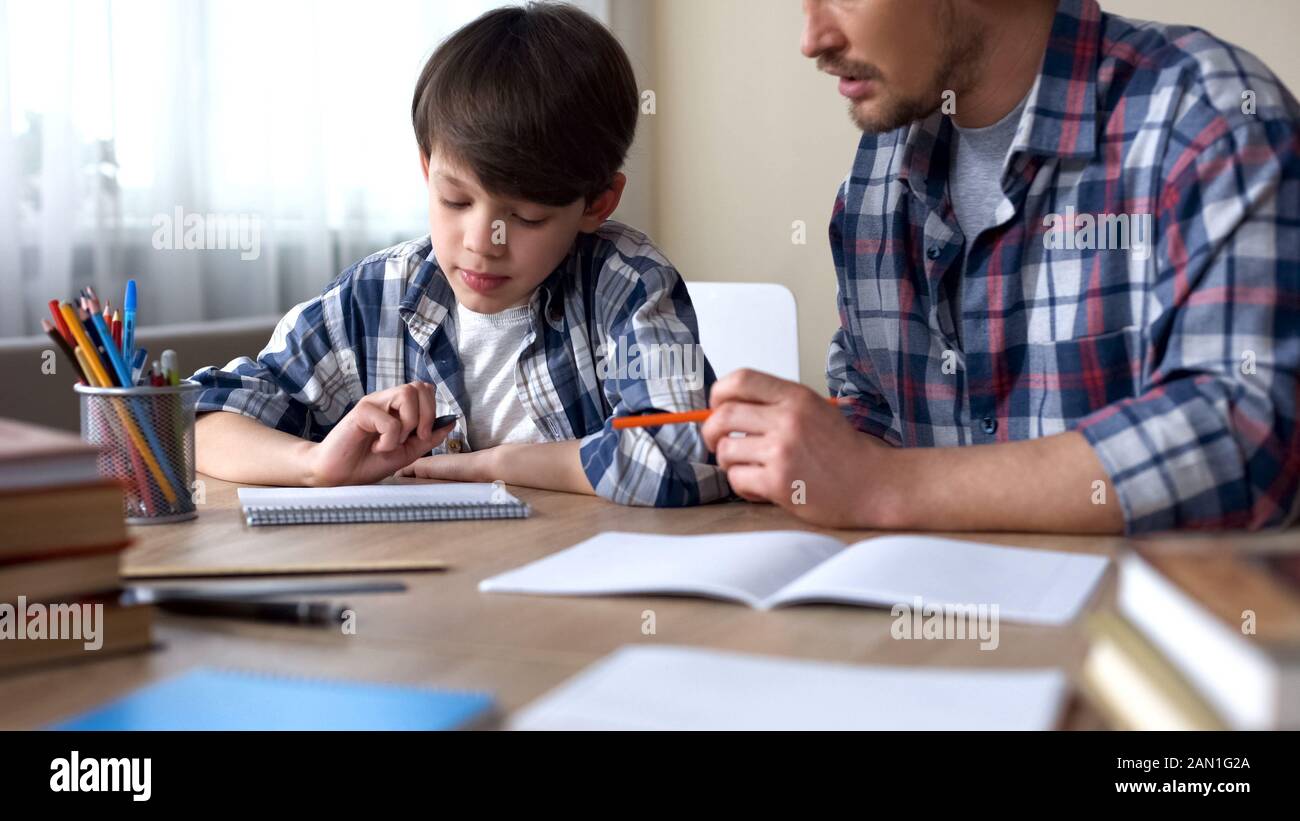 Father and son doing homework together, dad explaining task, school ...
