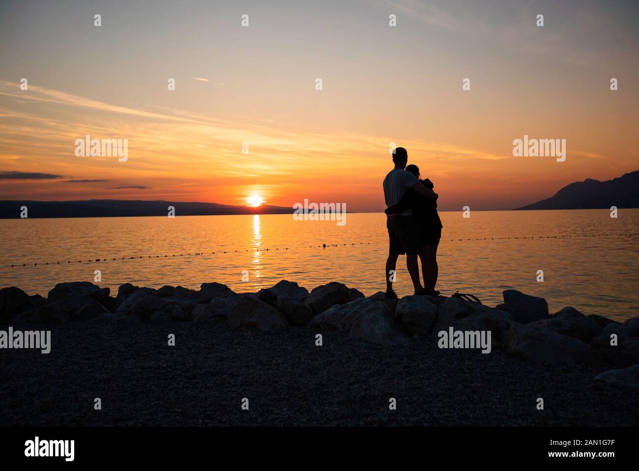 Couple standing rock sunset hi-res stock photography and images - Alamy