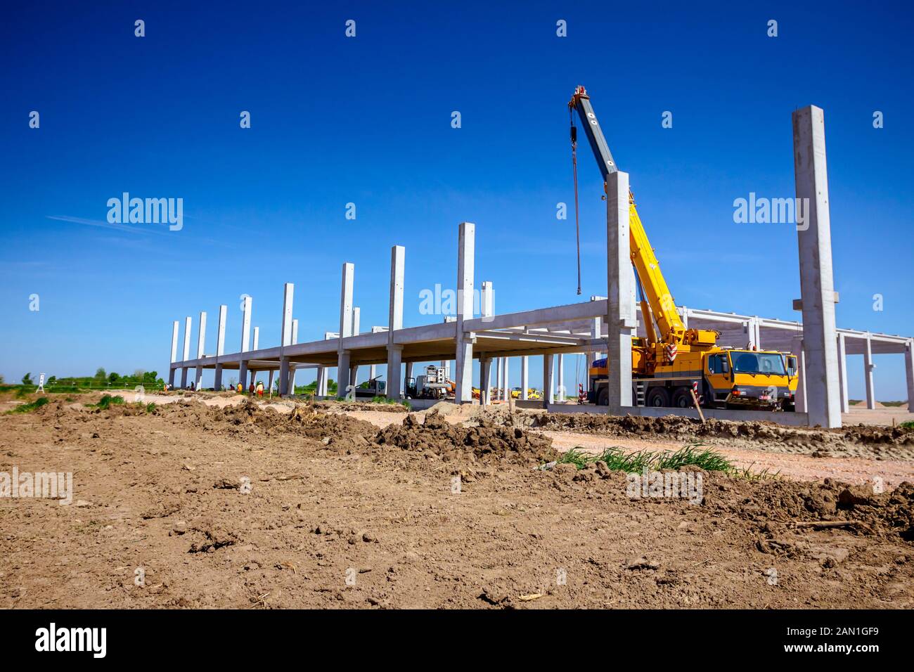 Assembly a huge concrete skeleton of industrial building with machinery ...