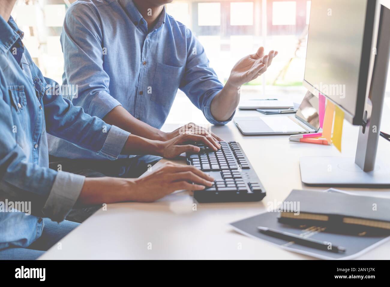 Young startup Programmers Sitting At Desks Working On Computers screen ...