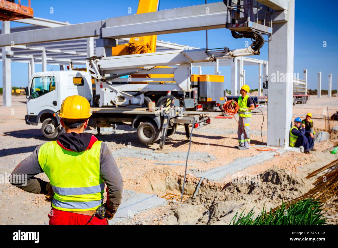 View from behind on construction worker with safety vest and yellow ...