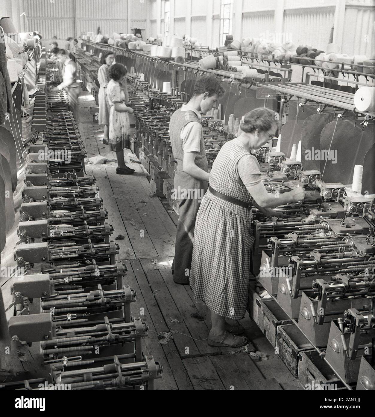 1950s, historical, male and female textile workers standing on wooden ...