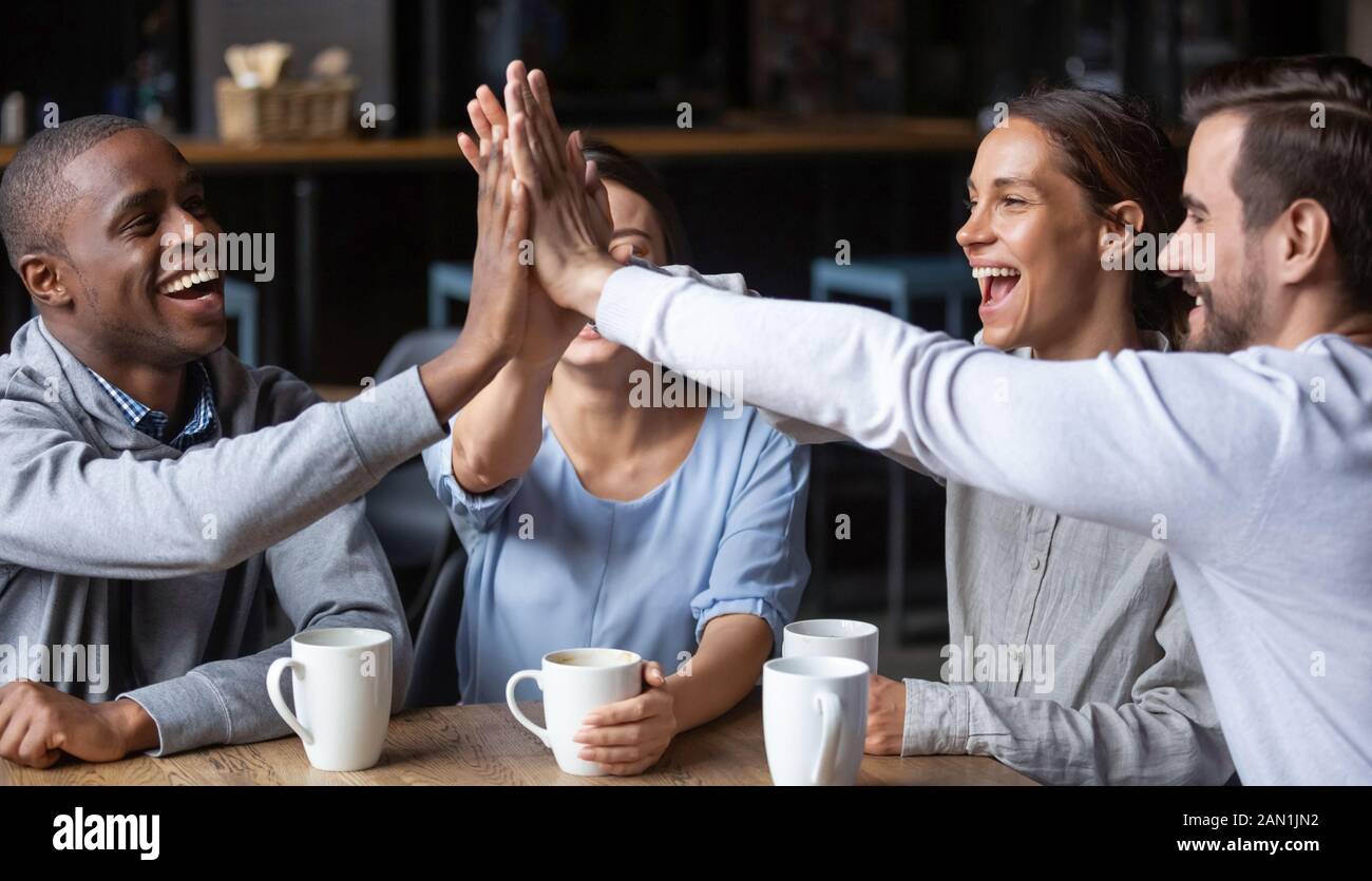Overjoyed young people give high five celebrating together Stock Photo ...