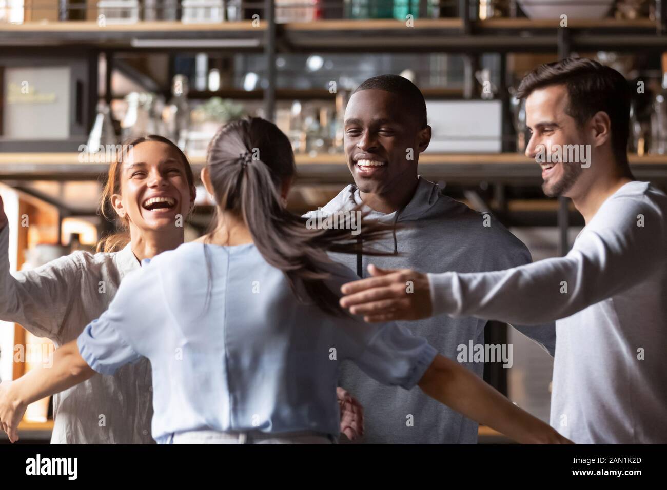 Happy diverse friends giving hug meeting girlfriend in cafe Stock Photo - Alamy