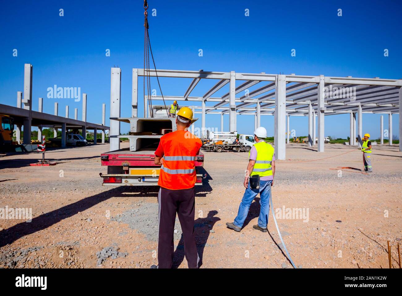 View from behind on construction worker with safety vest and yellow ...