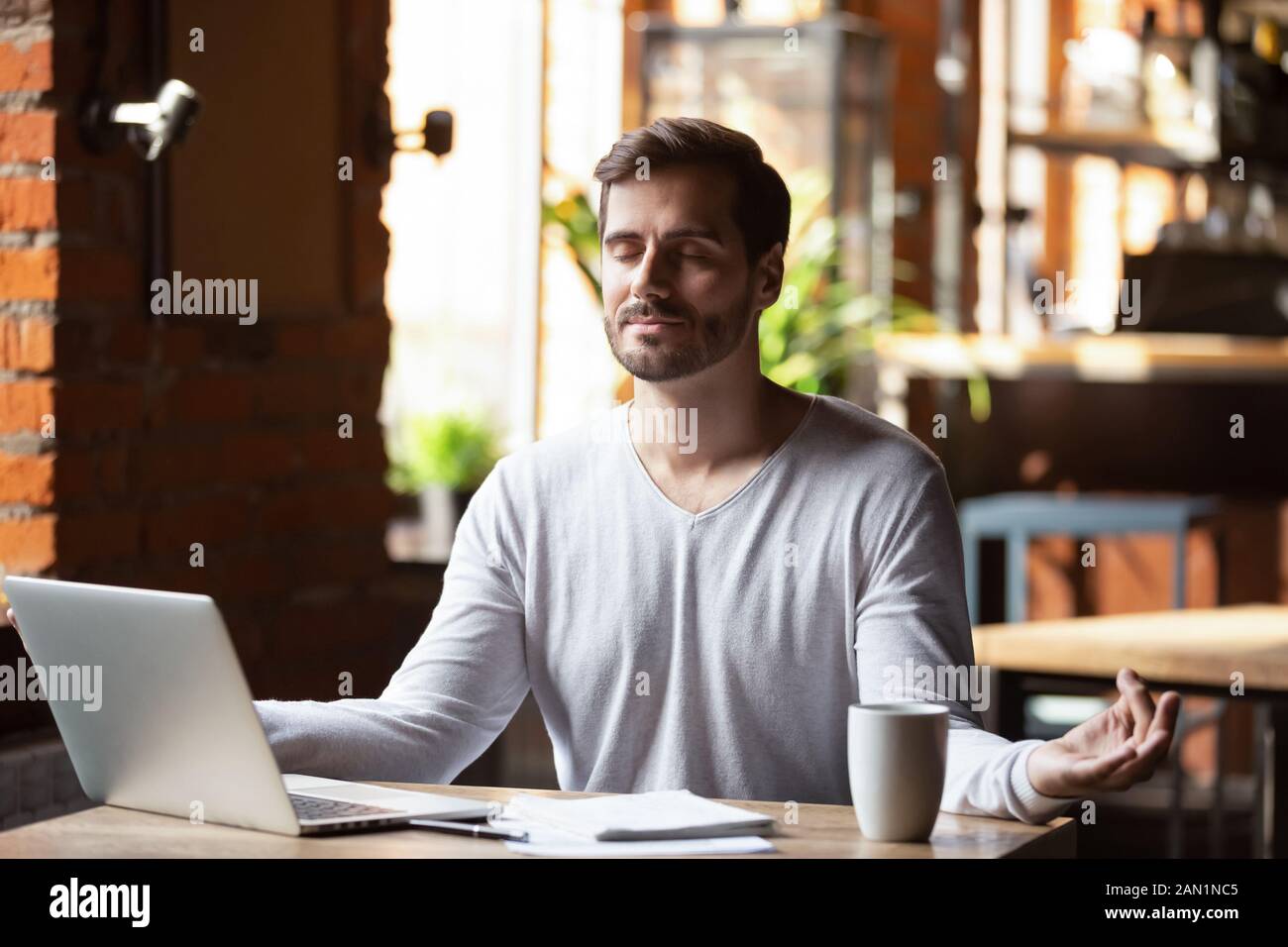 Calm male sit in cafe meditating controlling emotions Stock Photo - Alamy