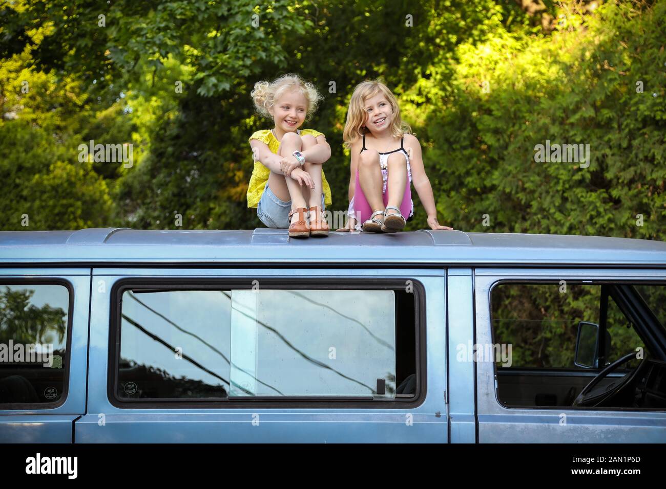 two girls sitting on roof of vintage car laughing and smiling Stock ...