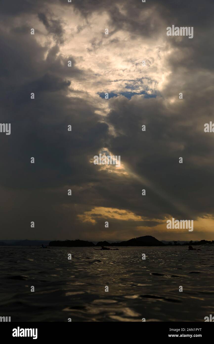 Sunlight shining through dark clouds Stock Photo - Alamy