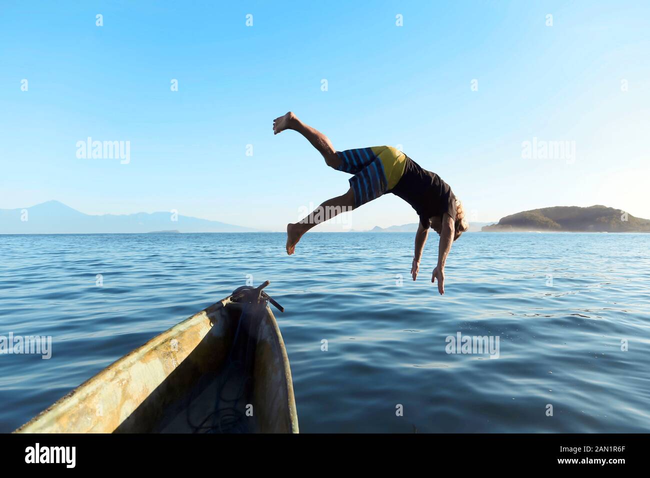 Man jumping from boat into sea Stock Photo - Alamy