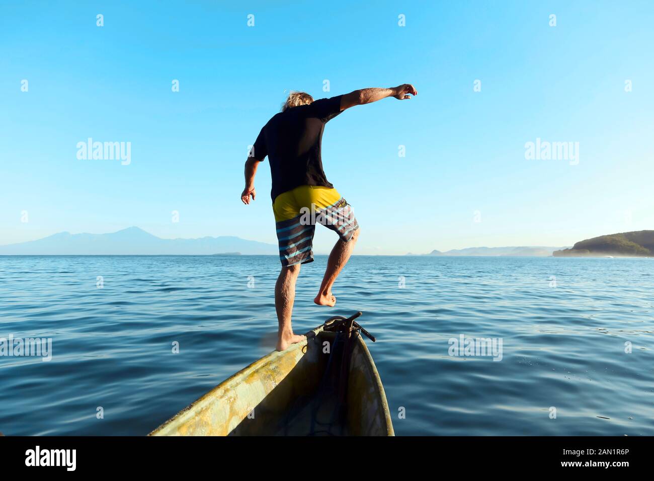 Man jumping from boat into sea Stock Photo - Alamy