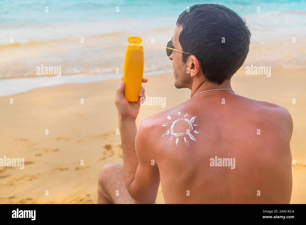 A man on the beach with sunscreen on his back. Selective focus Stock ...