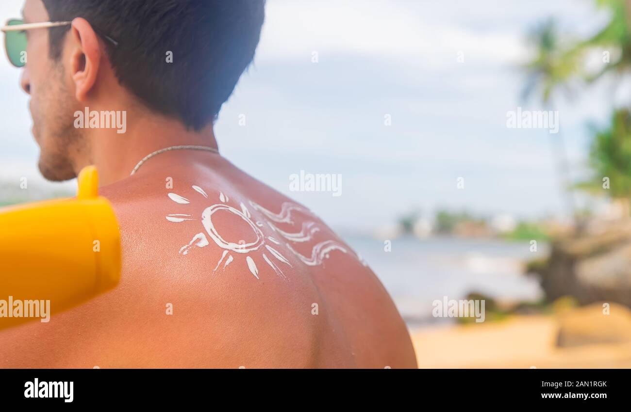 Male applying sunscreen on beach hi-res stock photography and images ...