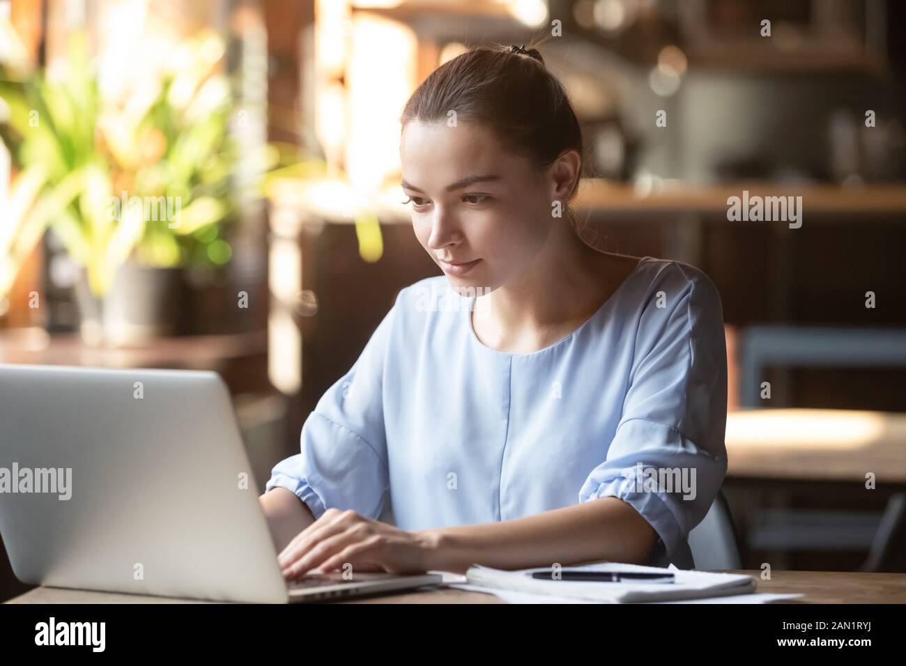Focused young woman busy typing on laptop studying Stock Photo - Alamy