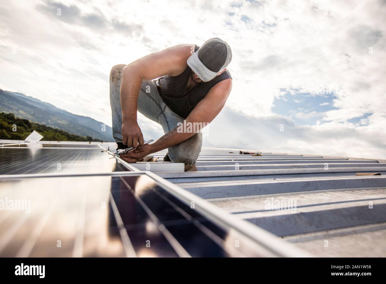 construction worker installs solar panels on rooftop Stock Photo - Alamy