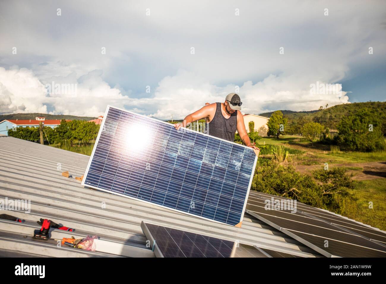 worker instals solar panels on top of building Stock Photo - Alamy