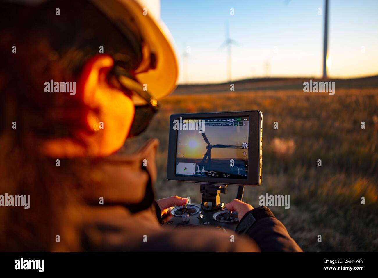 Female drone pilot flies in a wind farm at sunrise Stock Photo - Alamy