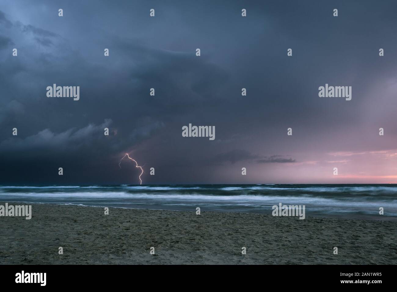Lightning bolt from a thunderstorm over sea at sunset Stock Photo - Alamy