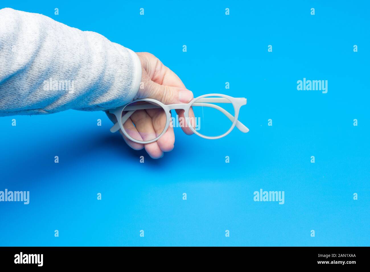 Eyeglasses in the hand of an adult; Colored glasses and lenses, modern ...
