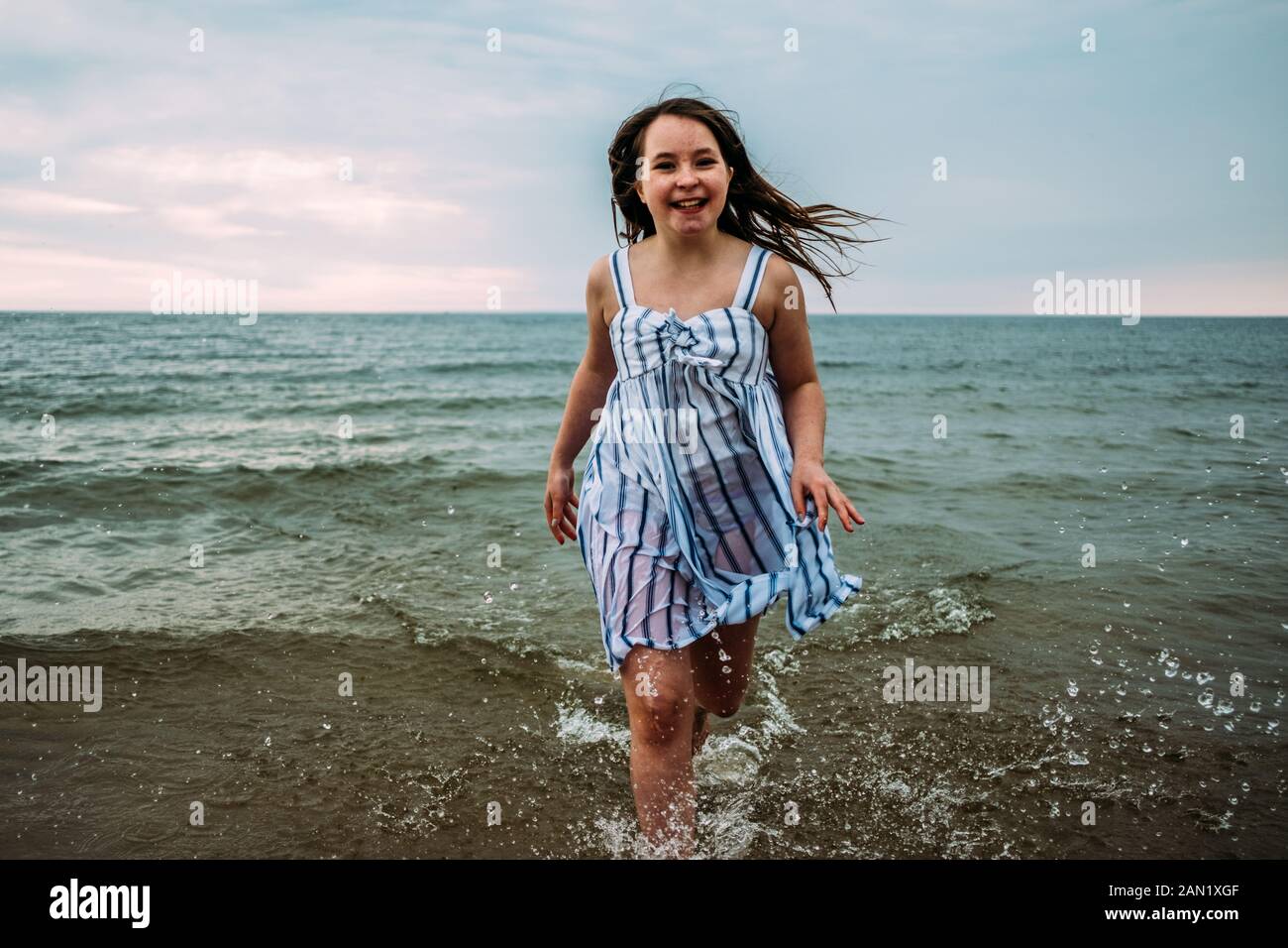young girl running through water in clothes in Lake Michigan Stock ...
