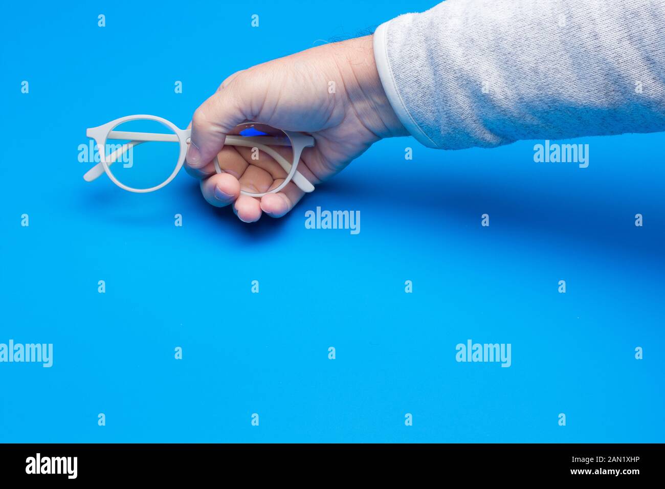 Eyeglasses in the hand of an adult; Colored glasses and lenses, modern ...