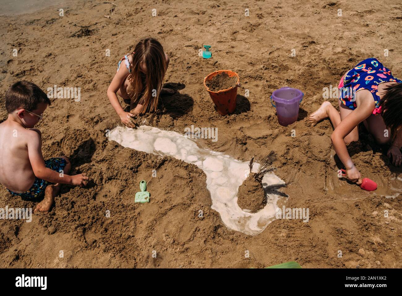 Kids playing in the sand digging hi-res stock photography and images ...