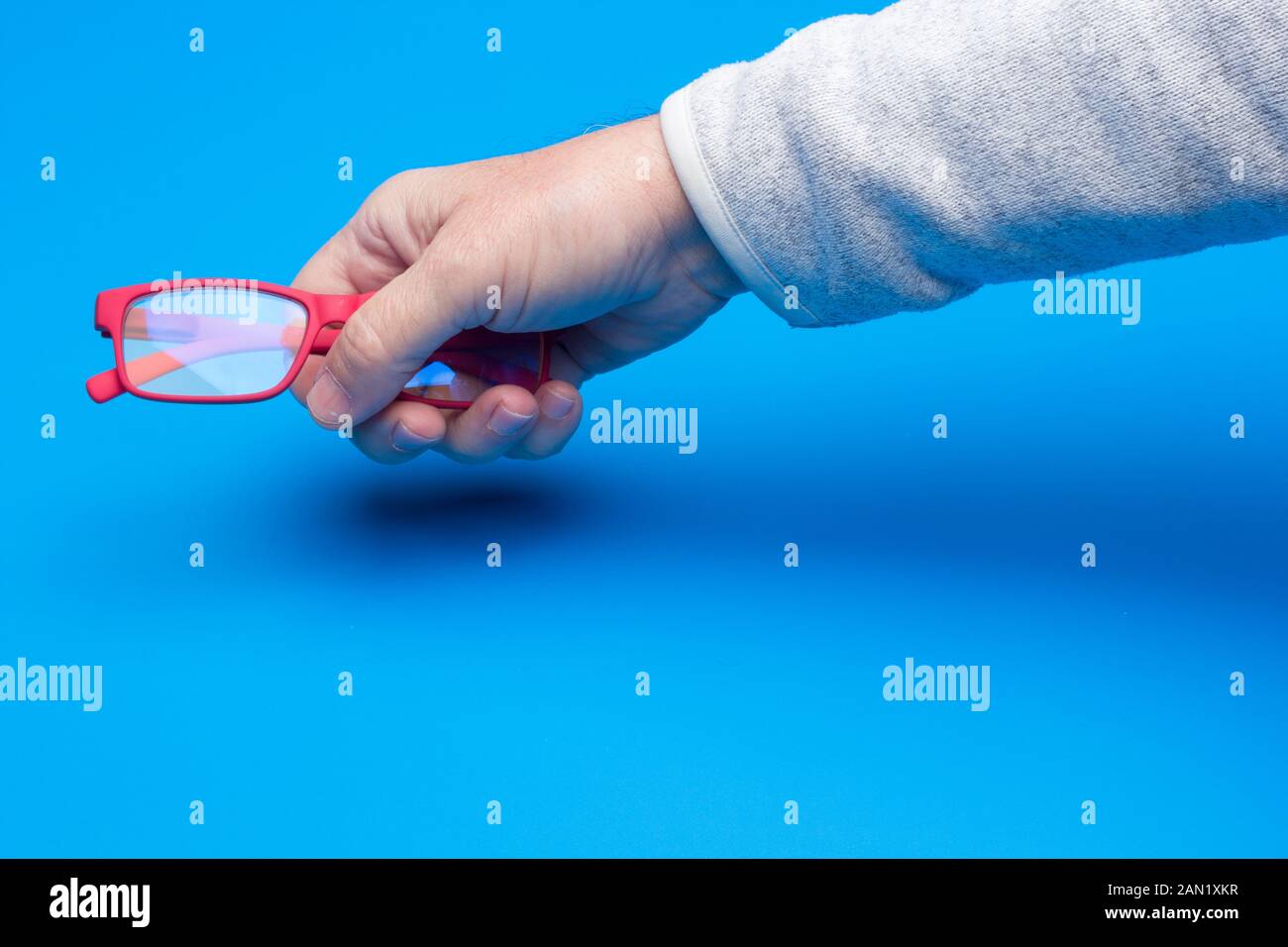 Eyeglasses in the hand of an adult; Colored glasses and lenses, modern ...