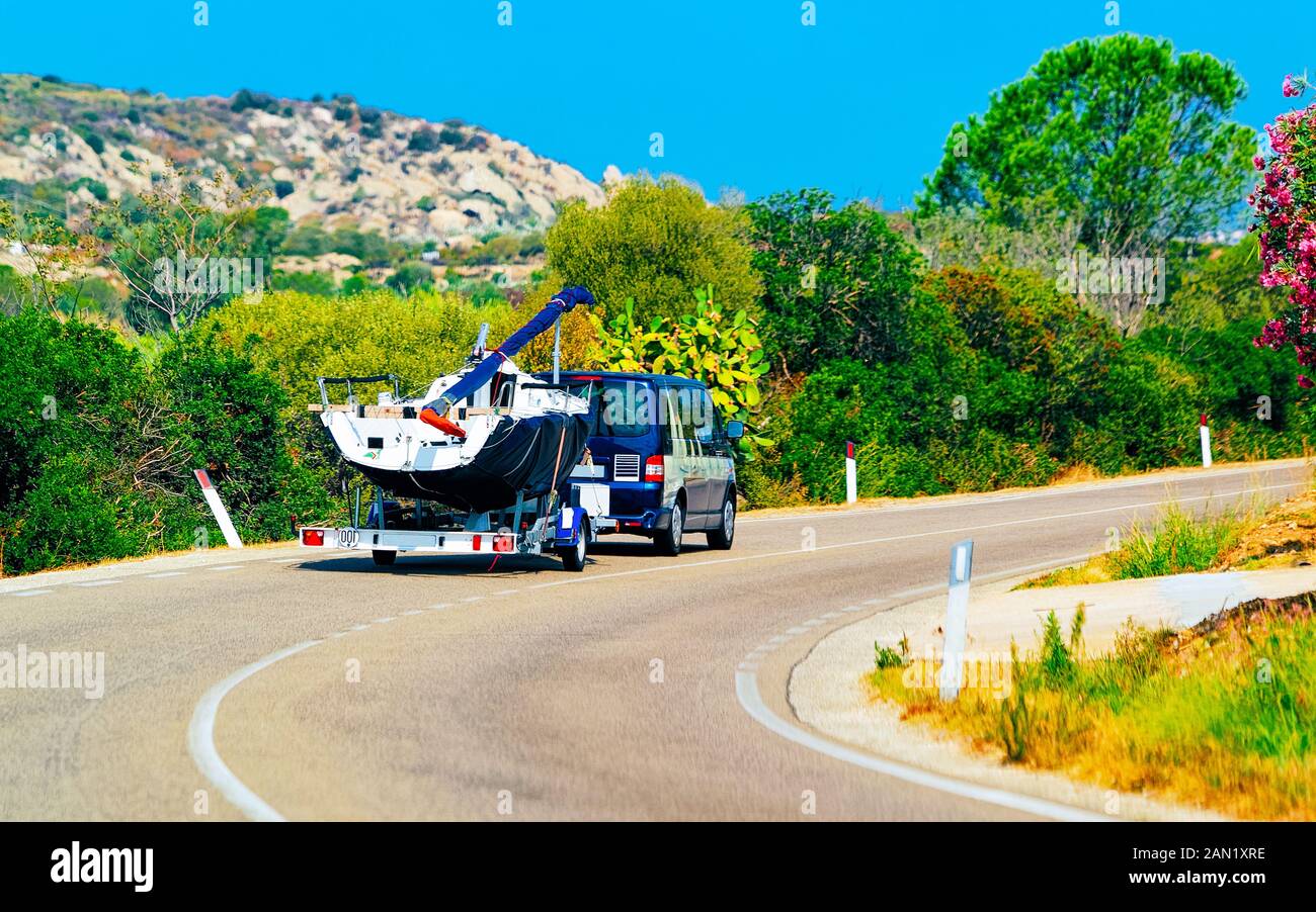Car with yacht or motor boat in road in Sardinia reflex Stock Photo - Alamy