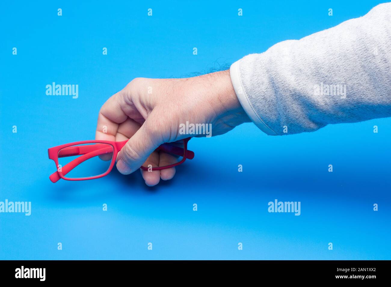Eyeglasses in the hand of an adult; Colored glasses and lenses, modern ...