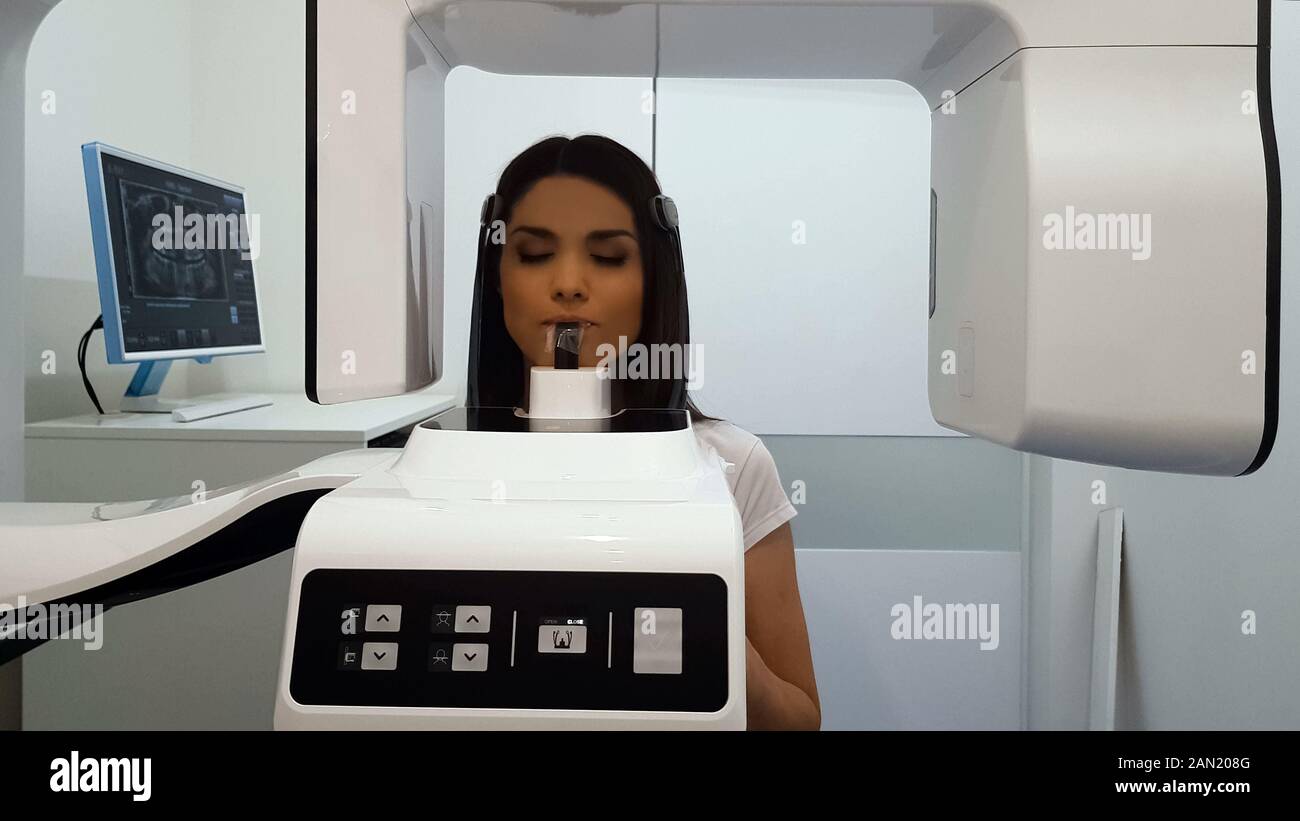 Panoramic x-ray machine in dentistry clinic, female patient undergoing ...