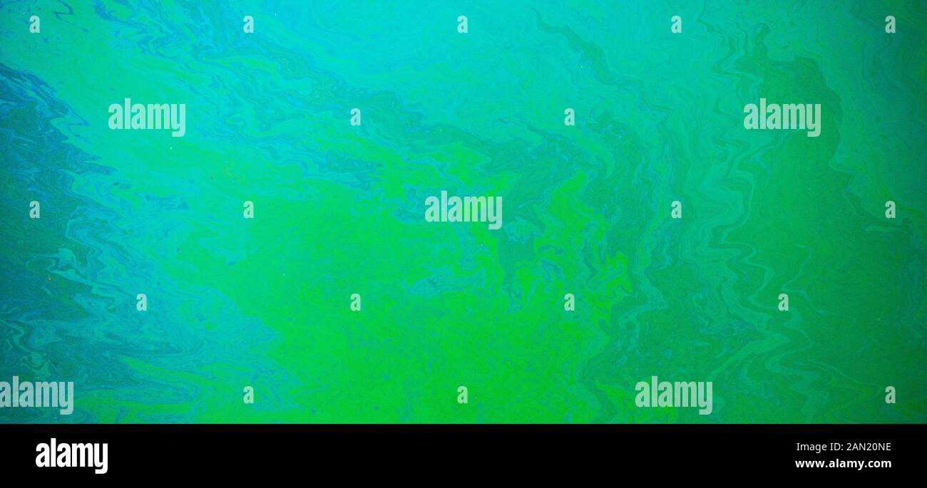 Blue, green, yellow color oil patterns on the surface of the water ...