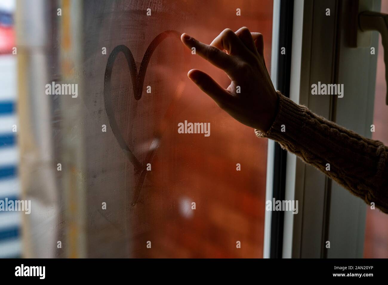 Hand drawing a heart with your finger on the window. Concept of love ...