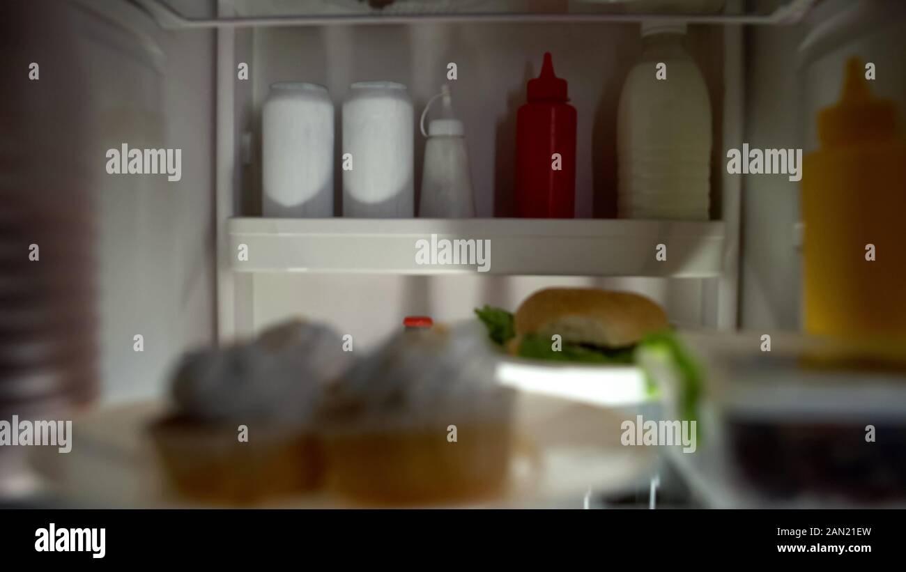 Closeup of junk food inside fridge, unhealthy nutrition, high calorie ...