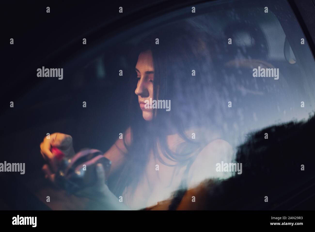 Young woman puts on makeup inside a car at sunset Stock Photo - Alamy