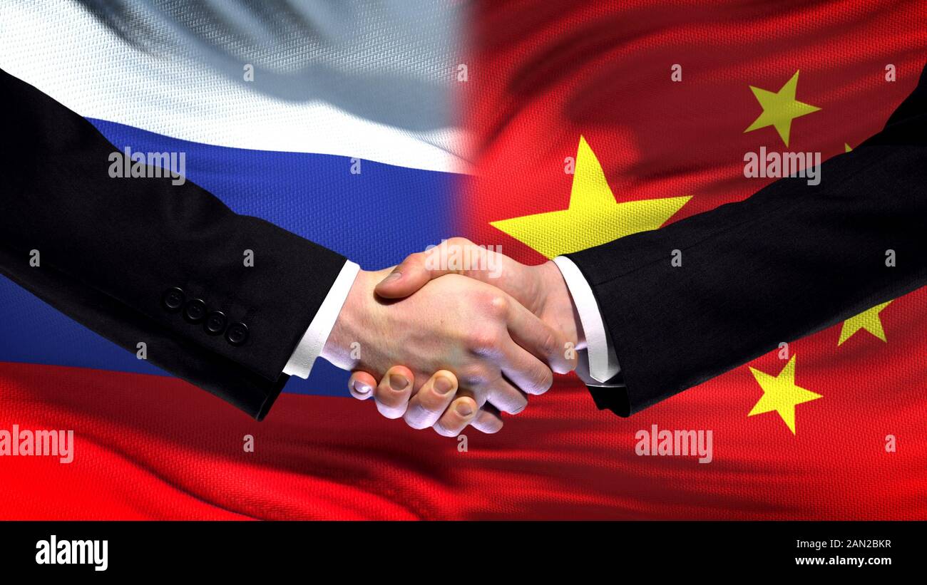 Russia and China handshake, international friendship summit, flag ...