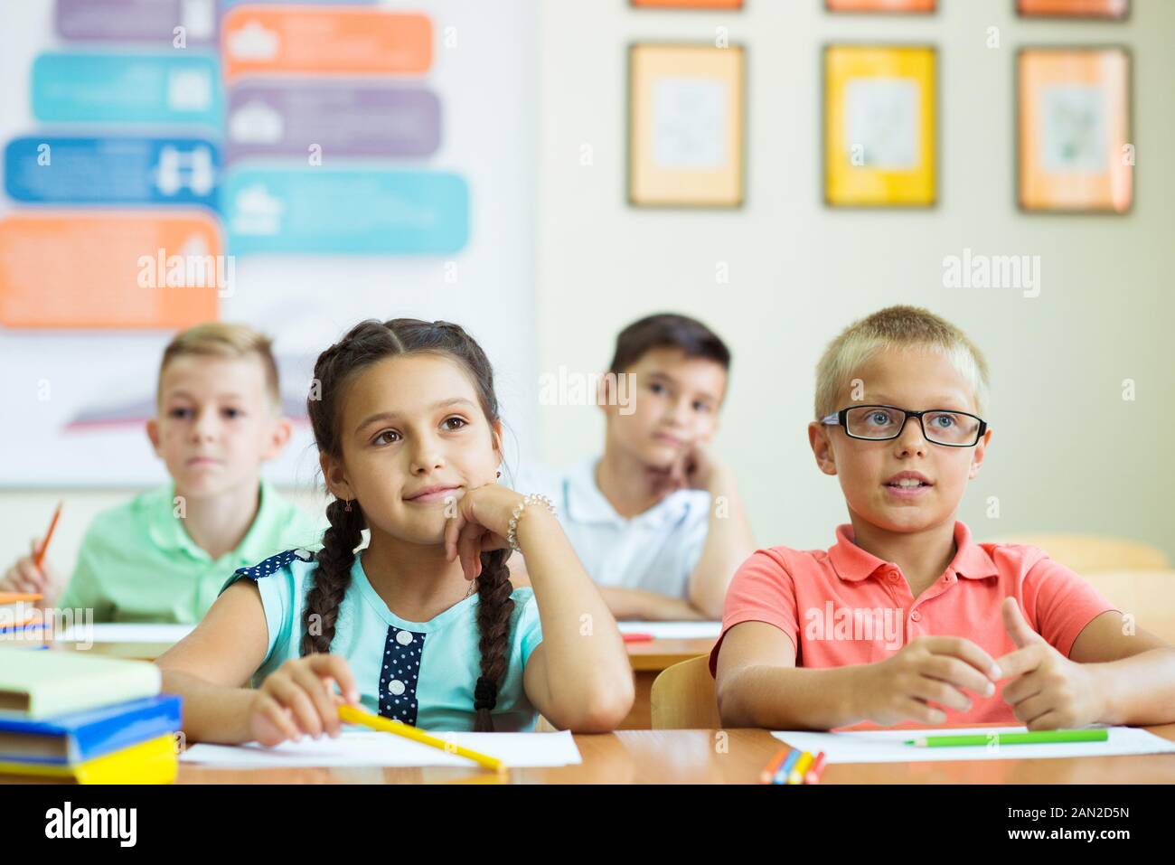 Happy schoolchildren studing and answer questions in classroom during a ...